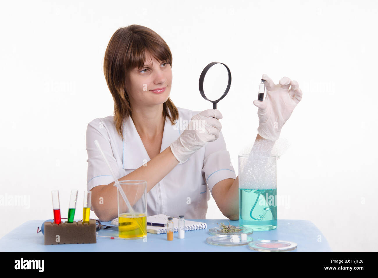 Scientist examines medicine through a magnifying glass Stock Photo - Alamy