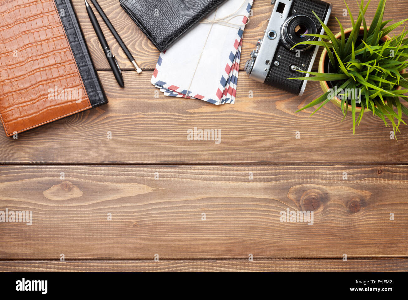 Camera and supplies on office wooden desk table. Top view with copy ...