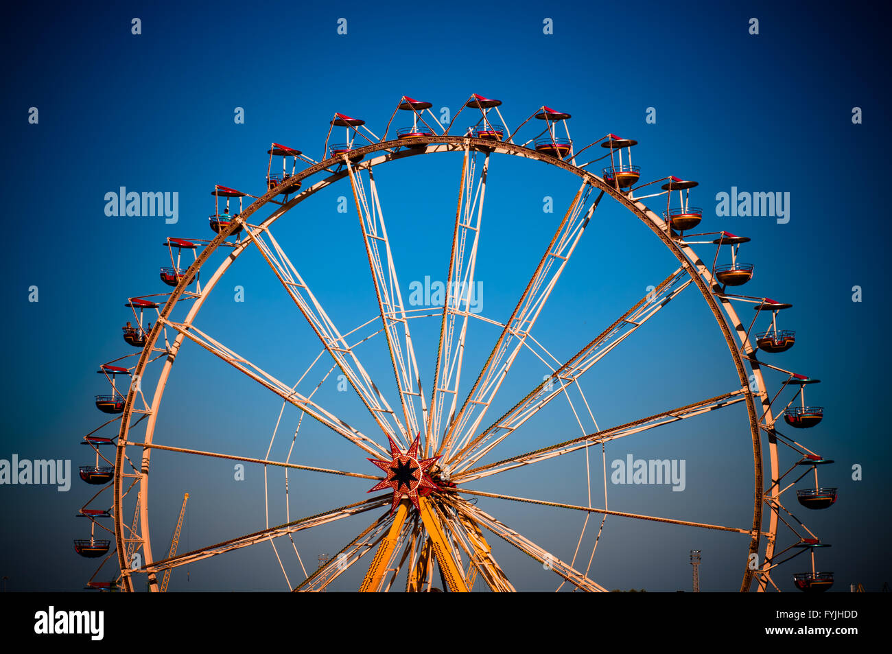 big wheel with multicolored cabins in amusement pa Stock Photo - Alamy