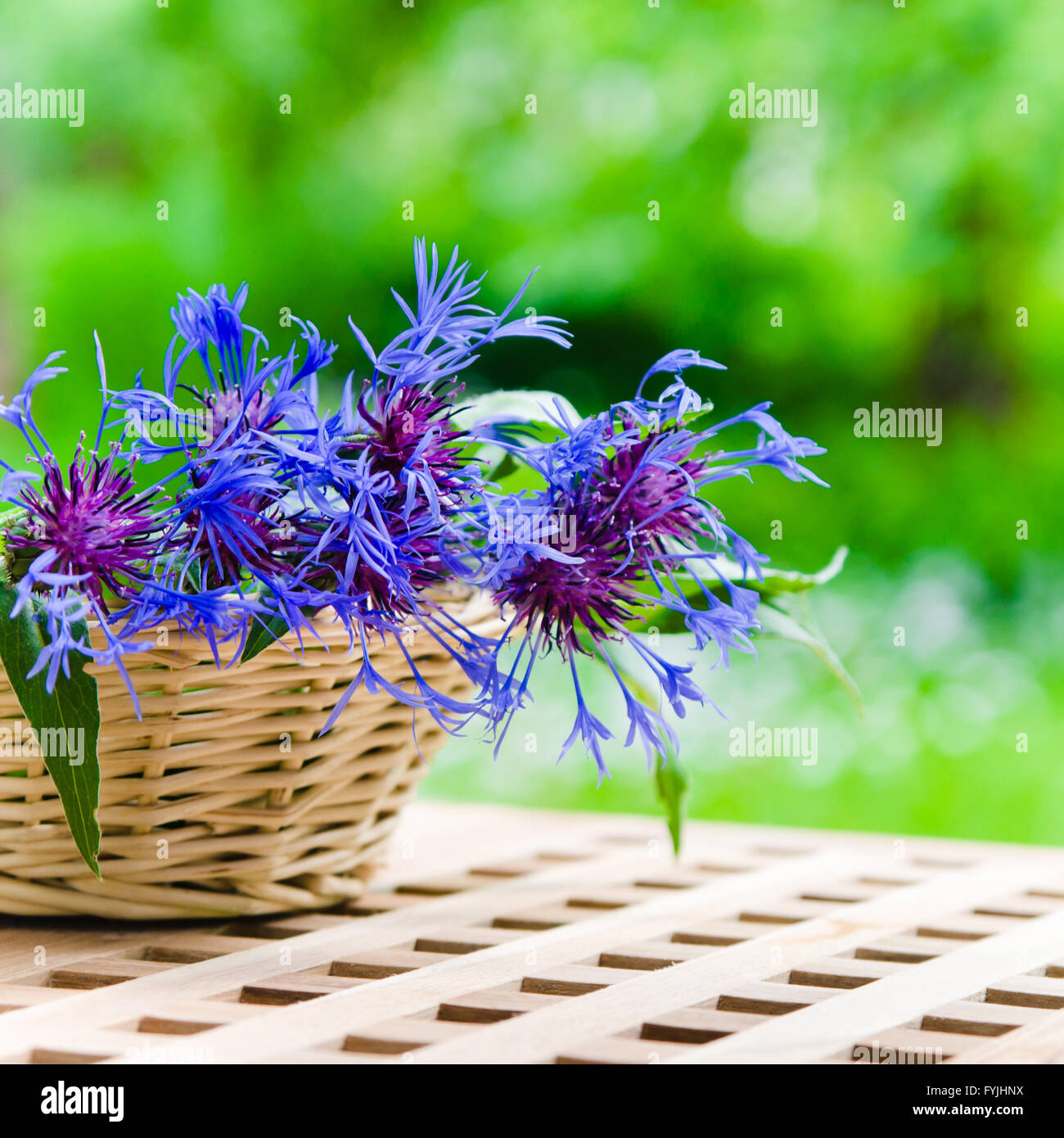 Bunch of cornflowers in a wicker basket. Summer background Stock Photo ...
