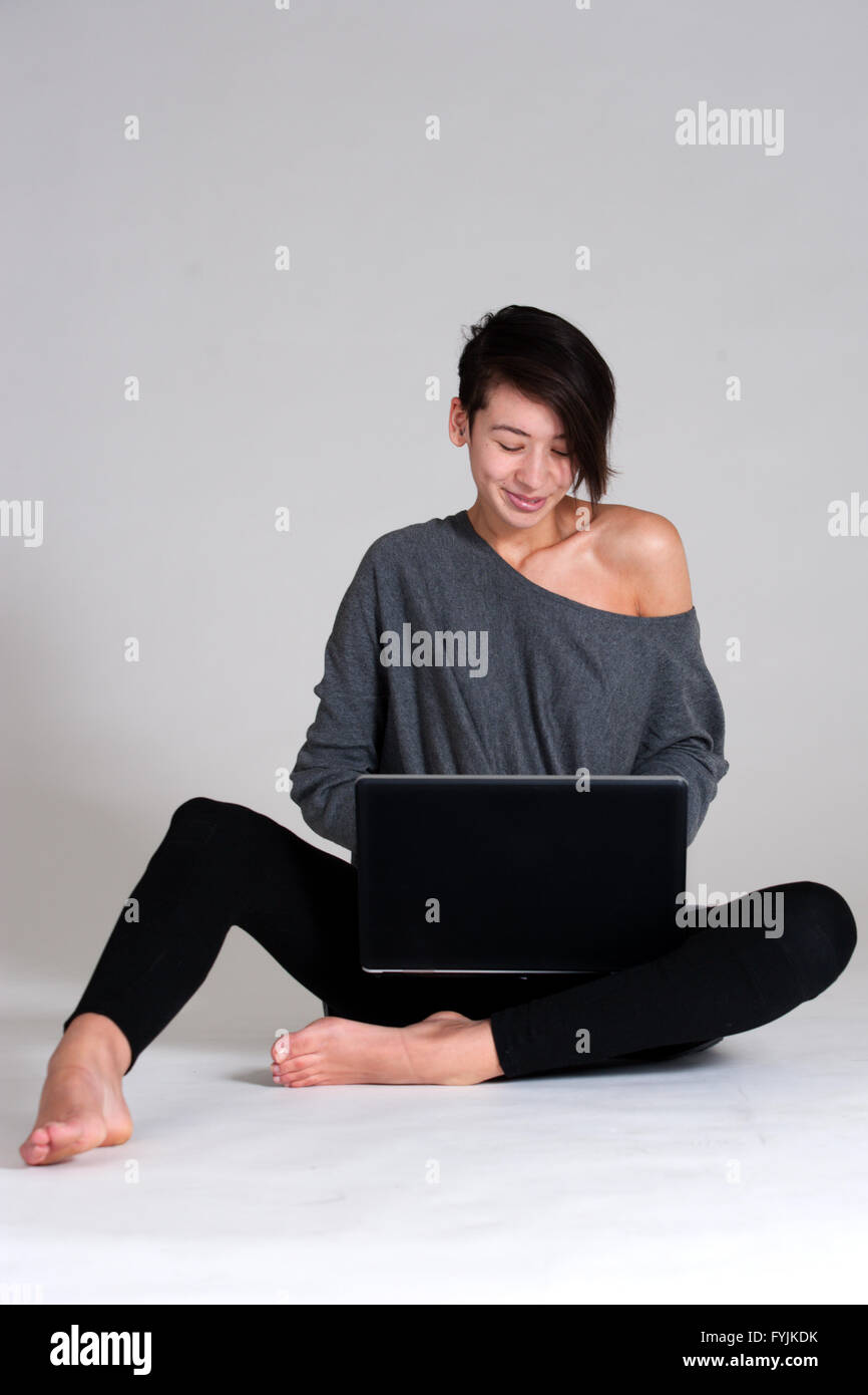 Young woman on floor with notebook Stock Photo - Alamy