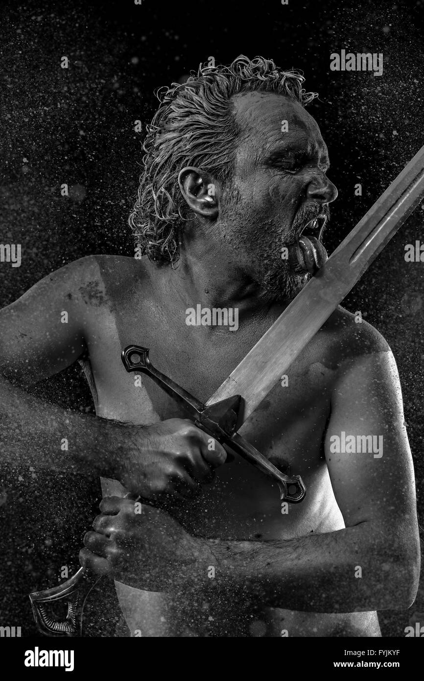 Wild Warrior with huge metal sword Stock Photo - Alamy