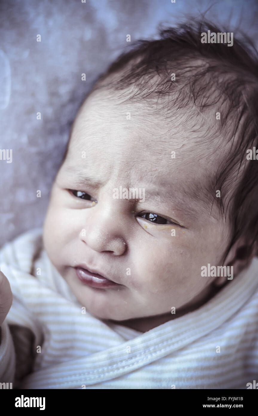 new born baby curled up sleeping on a blanket, multiple expressions ...