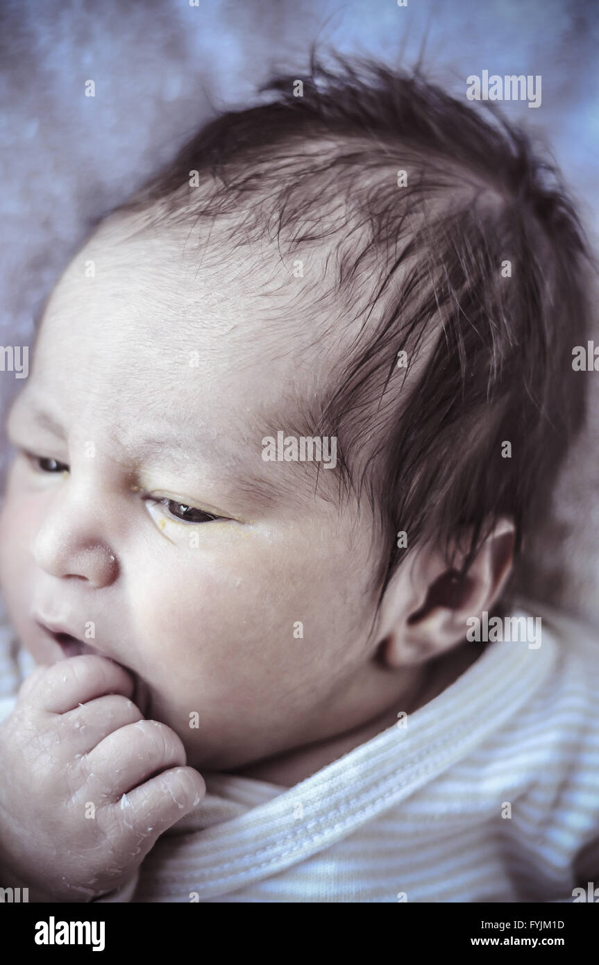 new born baby curled up sleeping on a blanket, multiple expressions ...