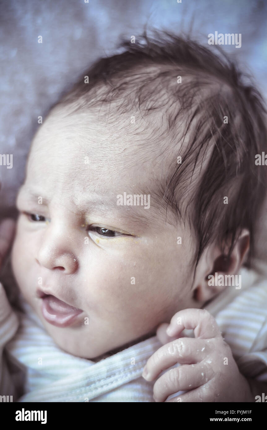 new born baby curled up sleeping on a blanket, multiple expressions ...