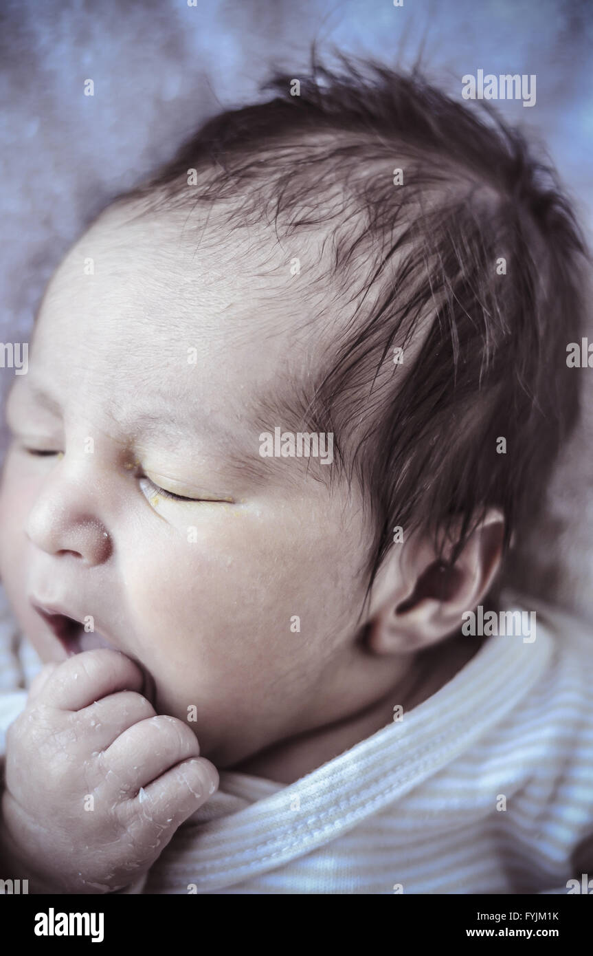 new born baby curled up sleeping on a blanket, multiple expressions ...
