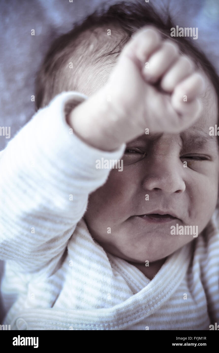 new born baby curled up sleeping on a blanket, multiple expressions ...