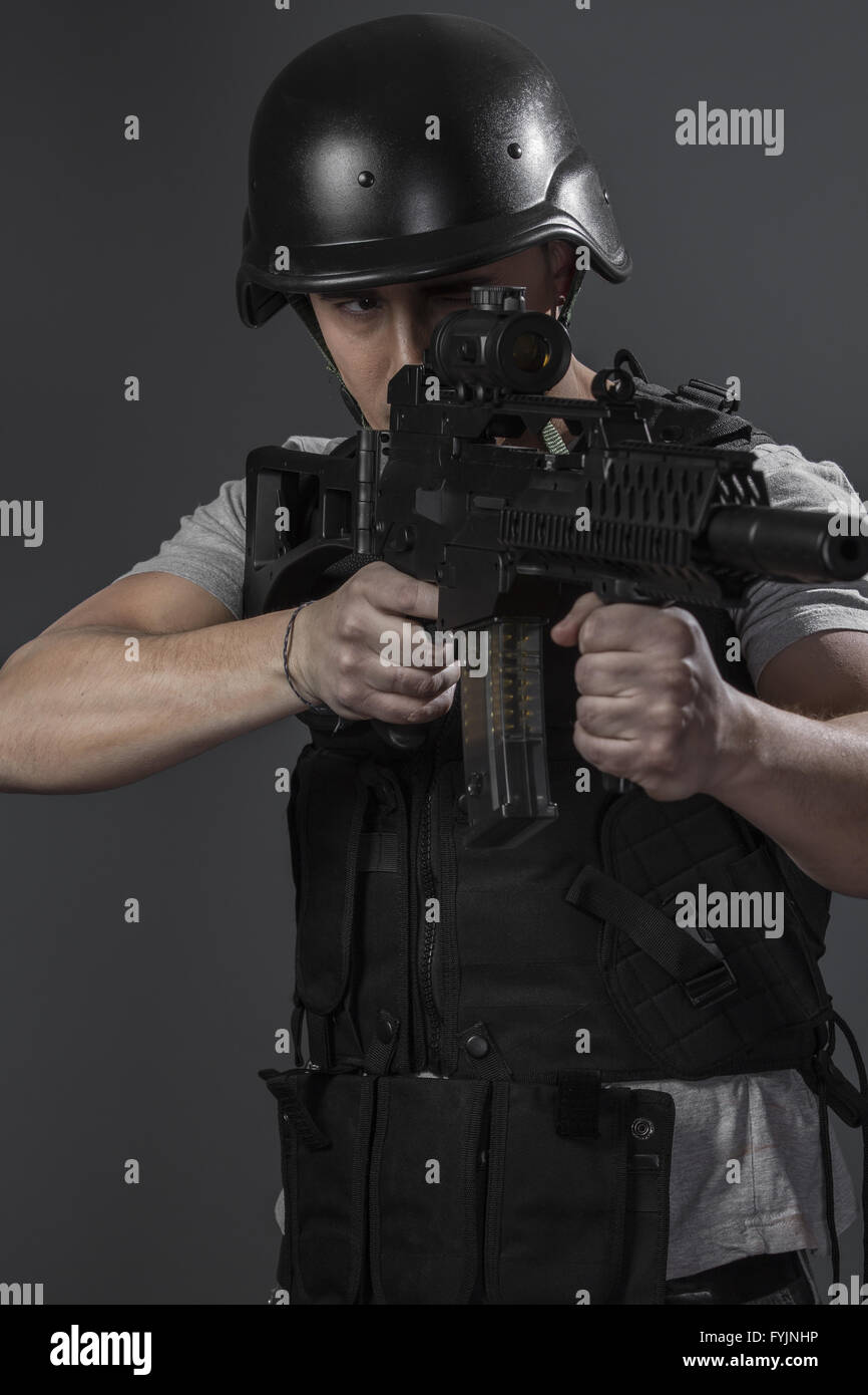 Military, paintball sport player wearing protective helmet aiming ...