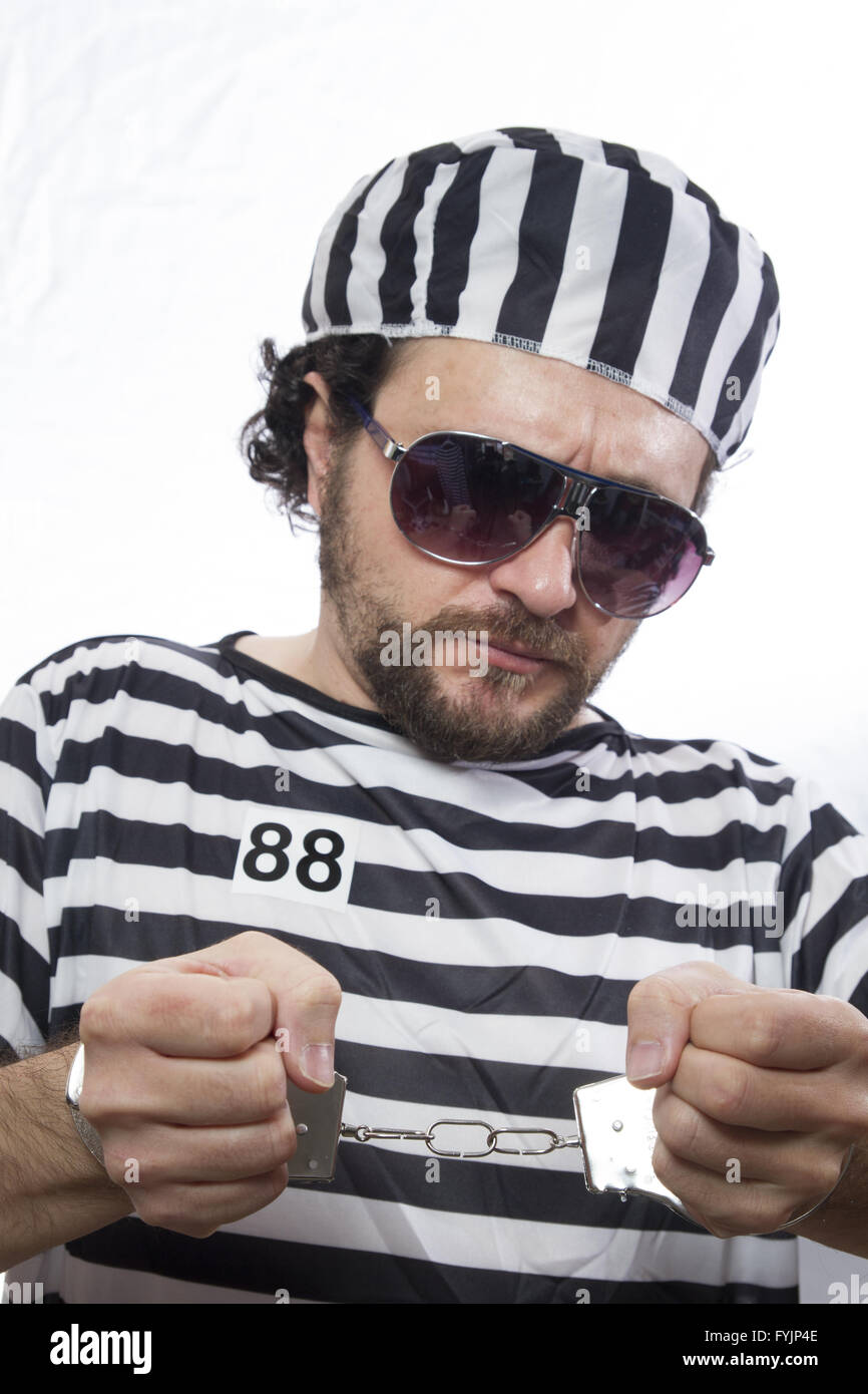 Desperate, portrait of a man prisoner in prison garb, over white ...