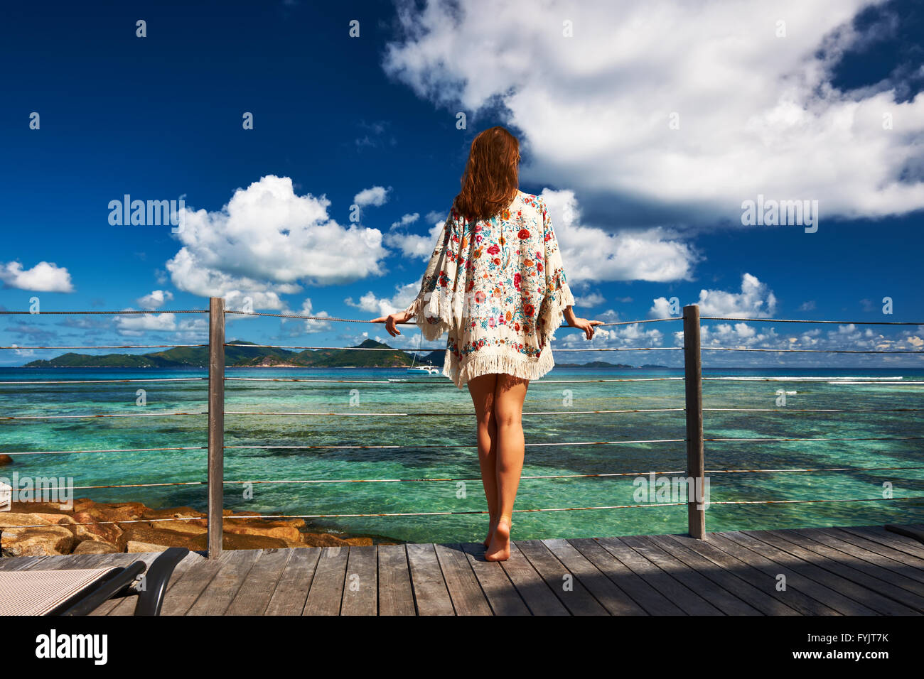 Woman on a beach jetty at Seychelles, La Digue Stock Photo - Alamy