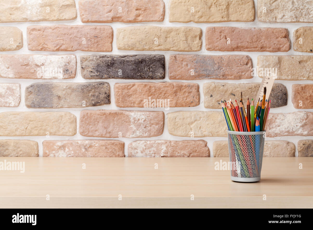 Office desk workplace table in front of brick wall. View with copy ...