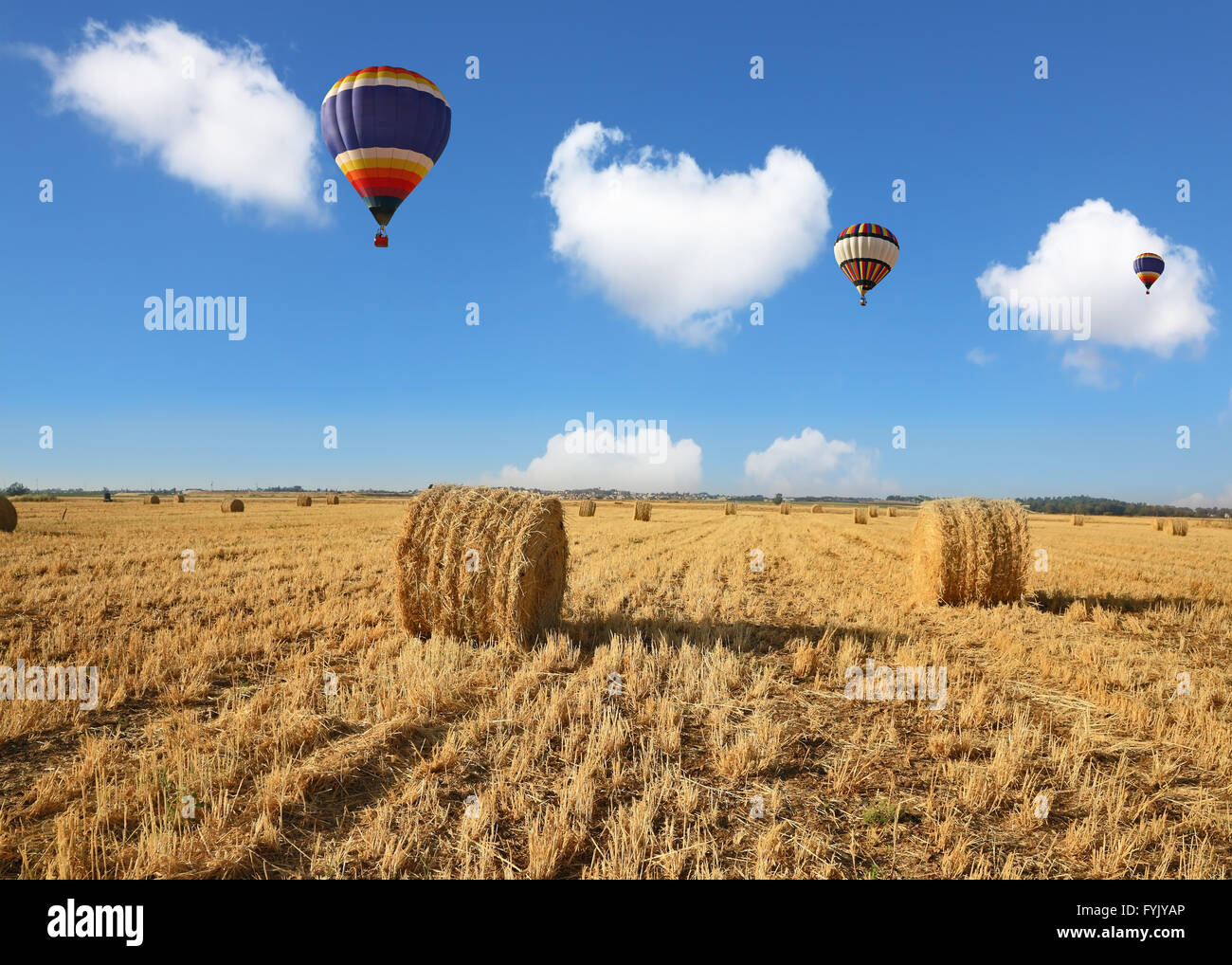 Three colorful balloons flying over the field Stock Photo - Alamy