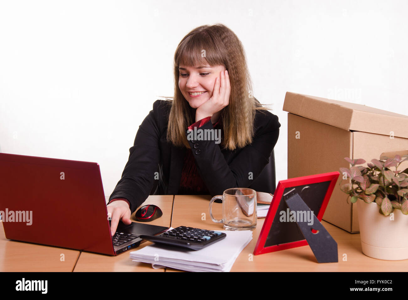 Office employee sitting at computer with a smile Stock Photo - Alamy