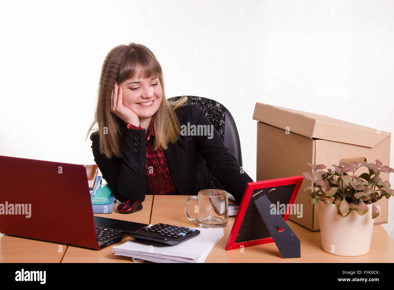 Smiling office employee looks at the picture frame Stock Photo - Alamy
