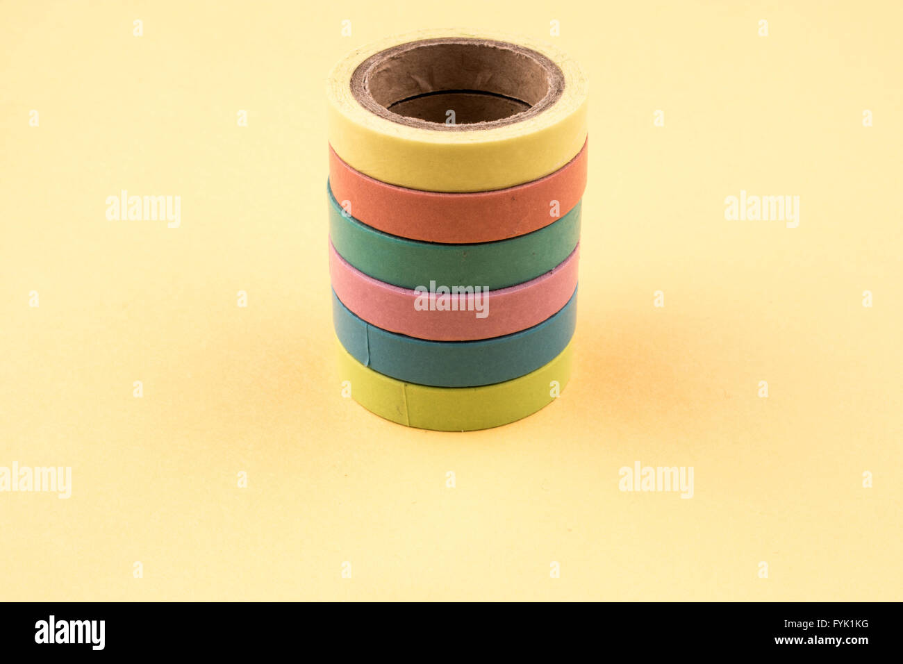 Color ribbon tapes on a yellow background Stock Photo - Alamy
