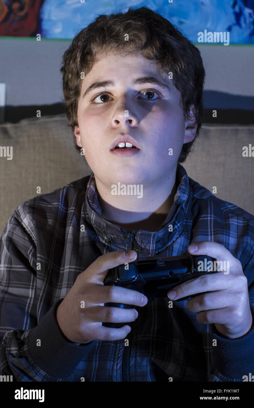 Teenage lifestyle. boy with joystick playing computer game at home ...