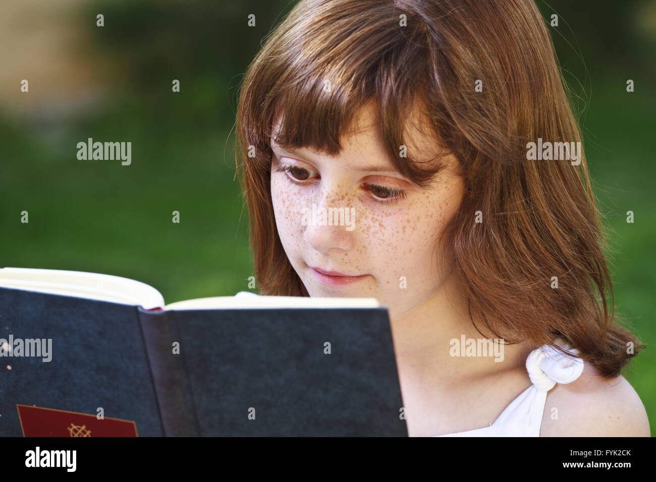 Literature.Young beautiful girl reading a book outdoor Stock Photo - Alamy
