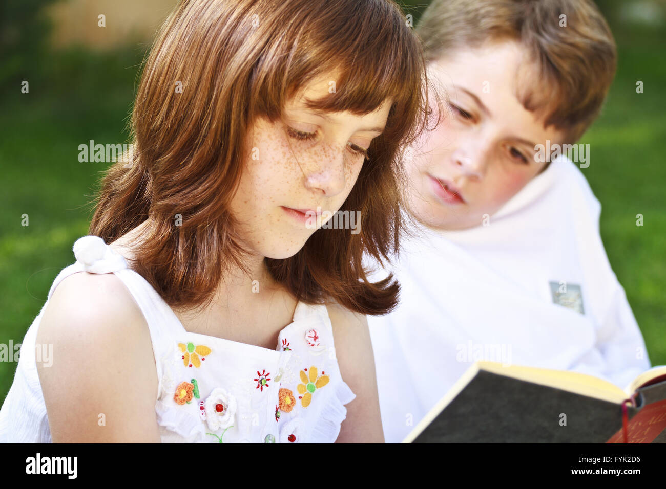 Students.Portrait of cute kids reading books in natural environment ...