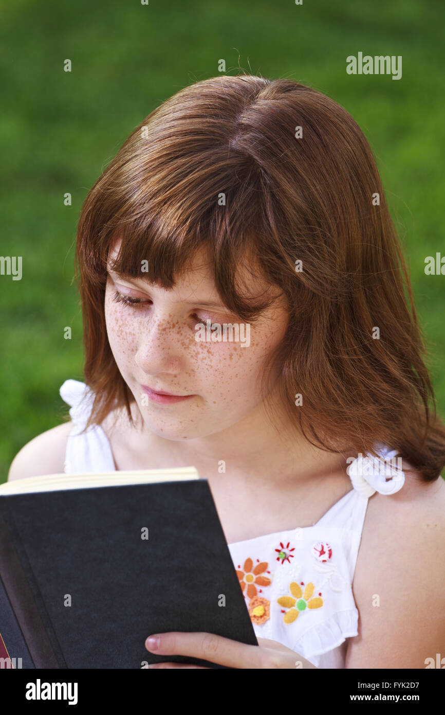 Pretty.Young beautiful girl reading a book outdoor Stock Photo - Alamy