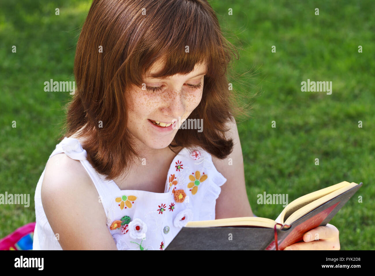 Young beautiful girl reading a book outdoor Stock Photo - Alamy
