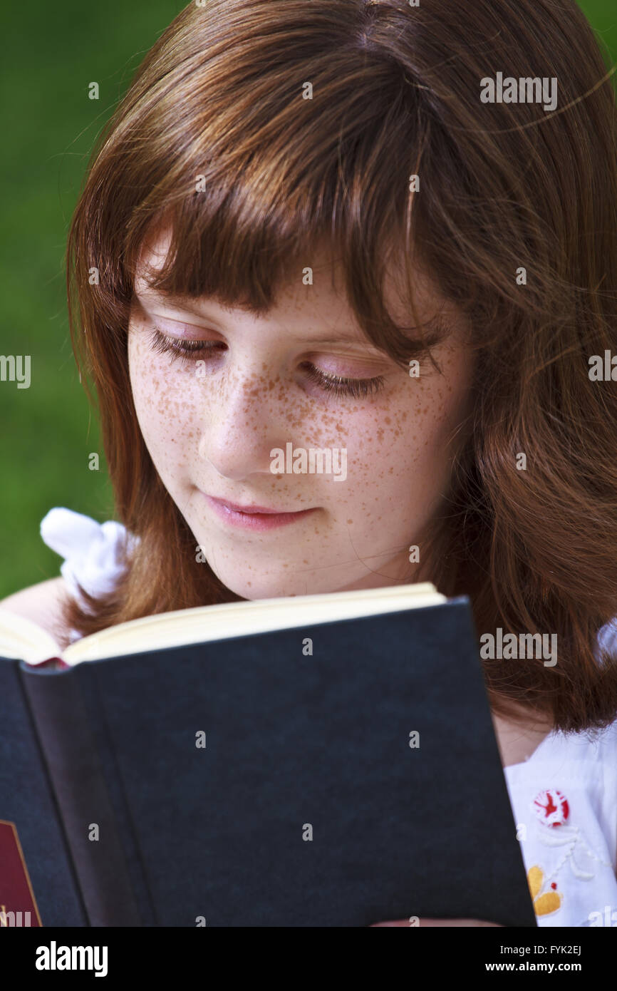 Relaxation.Young beautiful girl reading a book outdoor Stock Photo - Alamy
