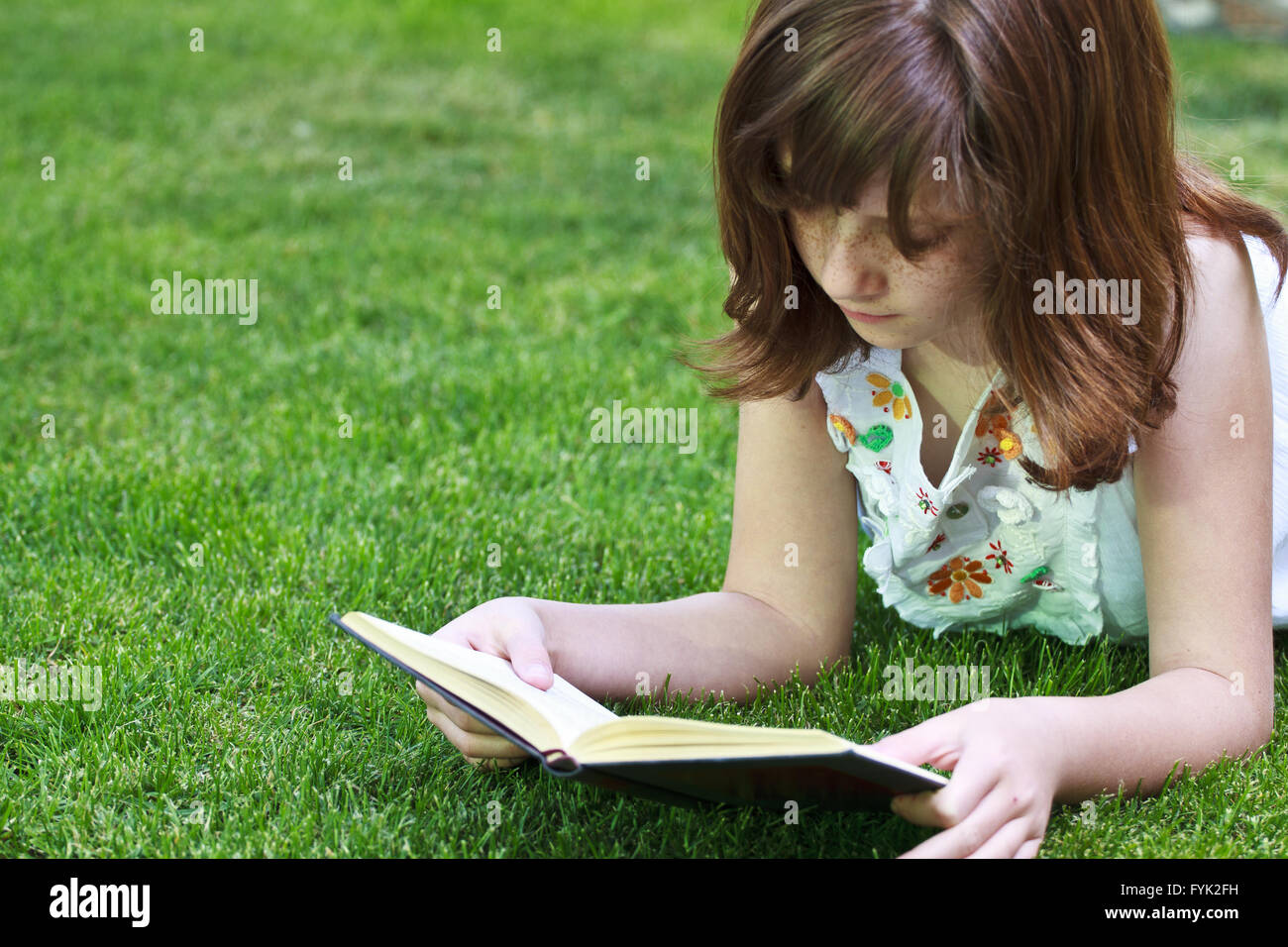 Read.Young beautiful girl reading a book outdoor Stock Photo - Alamy