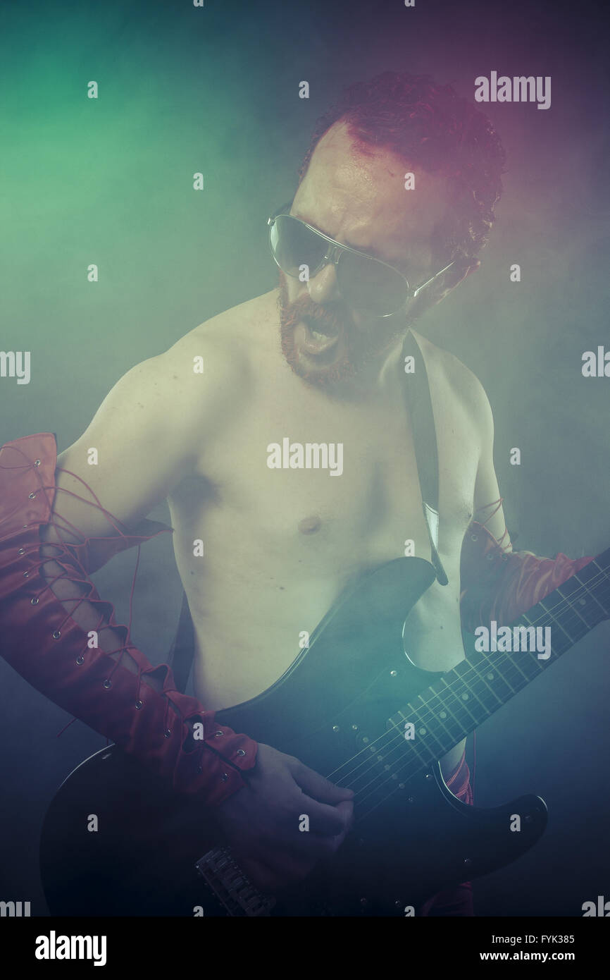 Play, rocker man with electric guitar in a rock concert Stock Photo - Alamy