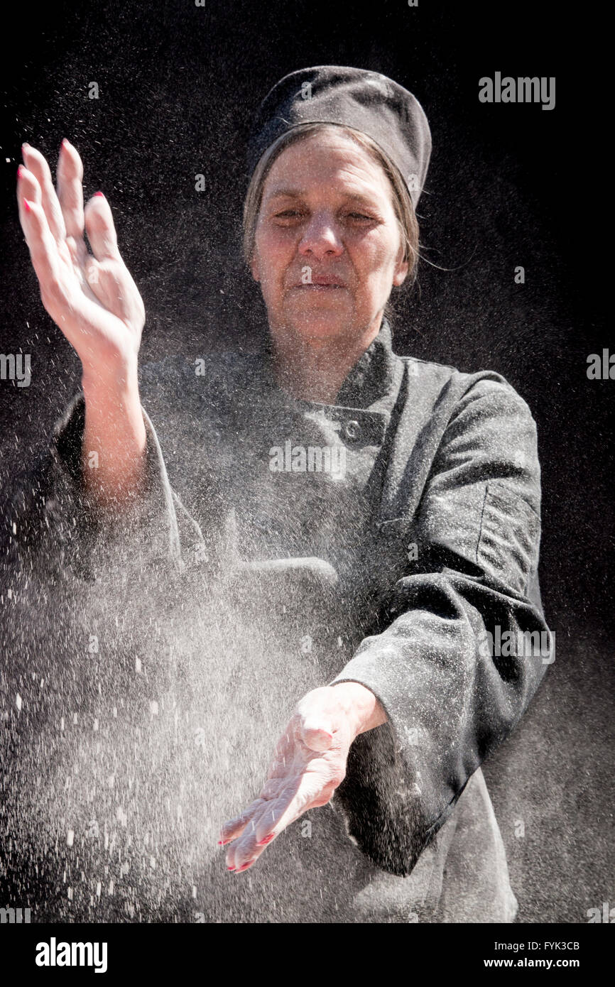 A woman baker brushing flour off her hands Stock Photo - Alamy