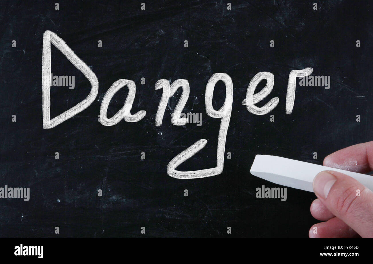 danger handwritten with chalk on a blackboard Stock Photo - Alamy