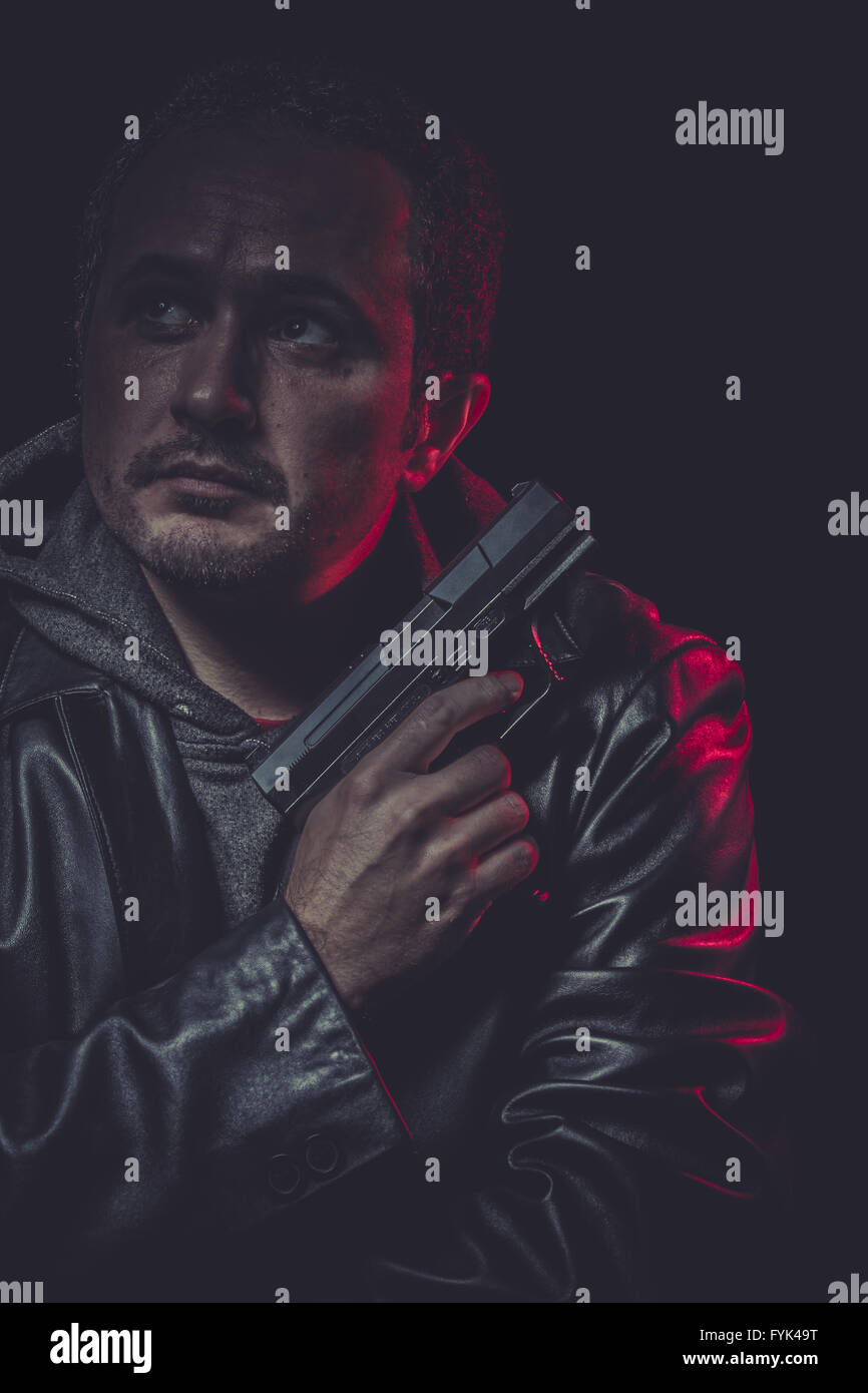 Assassin, man with black coat and gun Stock Photo - Alamy