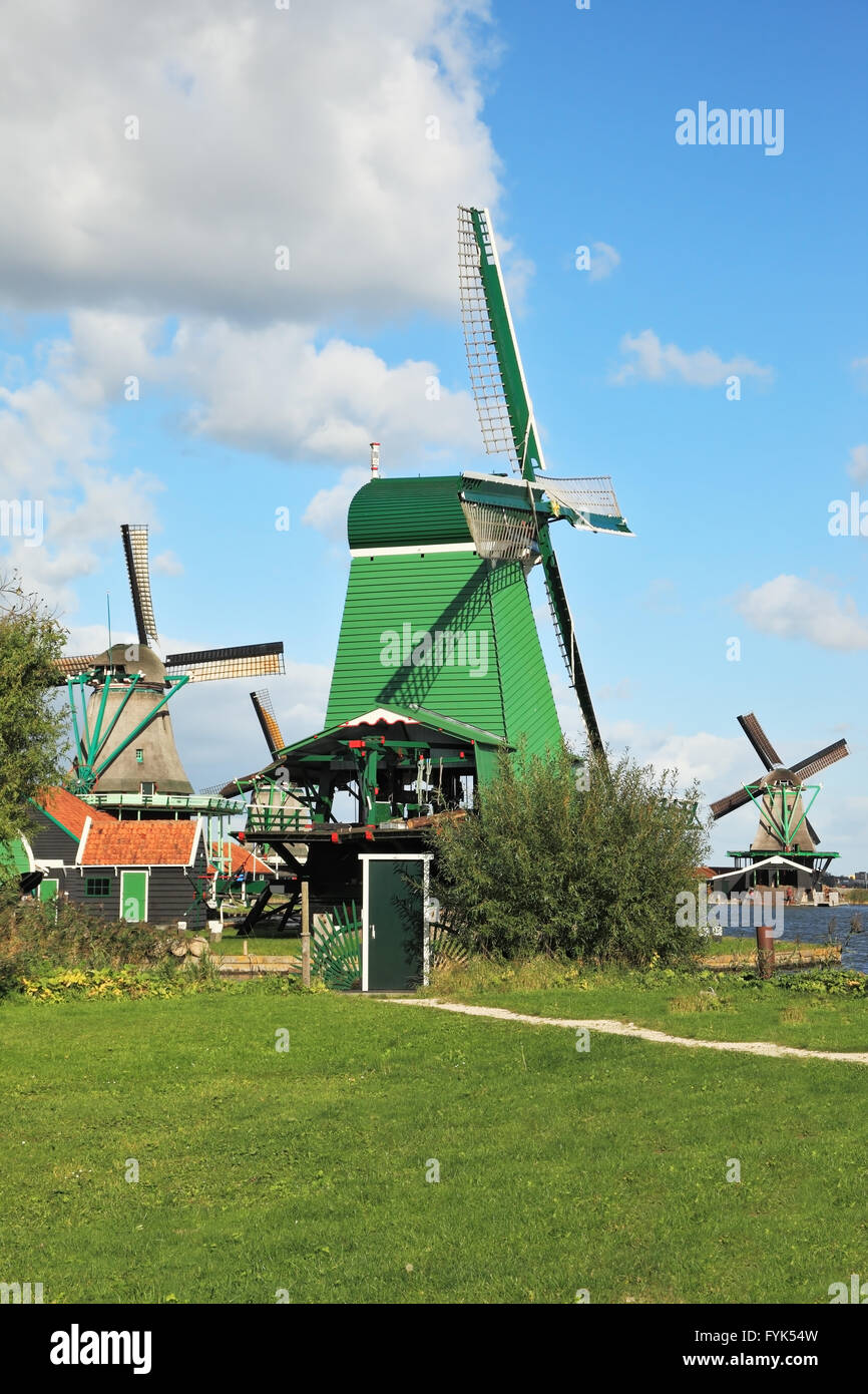 Three windmills and farm buildings on a green meadow Stock Photo - Alamy