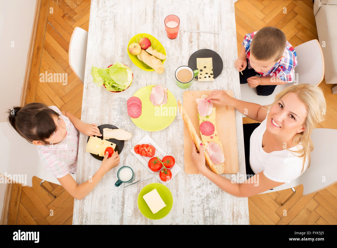 Happy family having breakfast at home Stock Photo - Alamy