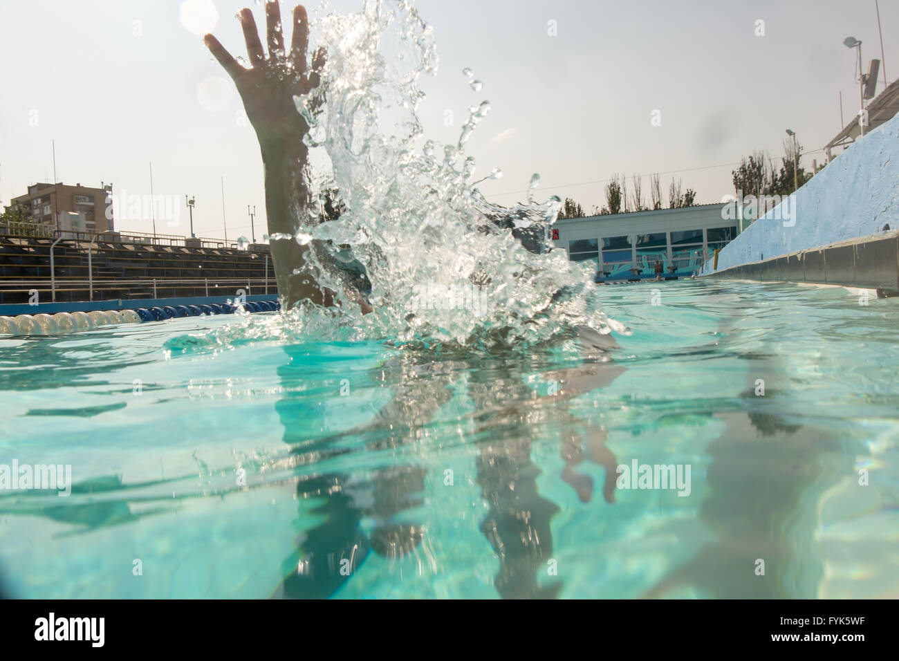 Boy dive in swimming pool and only hand over water Stock Photo - Alamy
