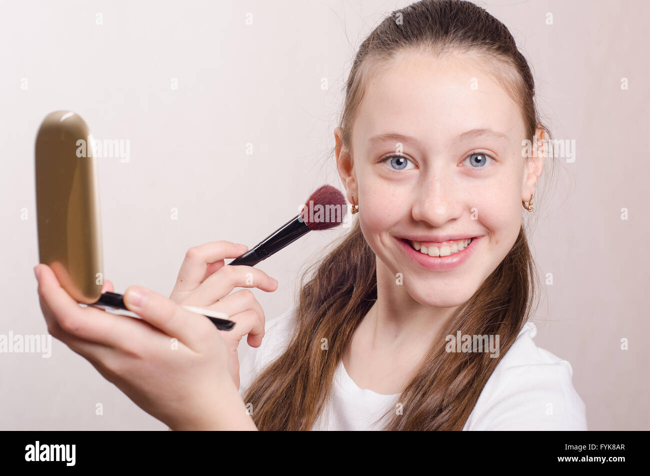 Teen learns to apply the powder on your face Stock Photo - Alamy