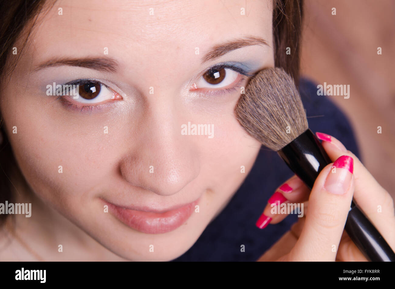 Makeup artist applies powder on face of beautiful girl Stock Photo - Alamy
