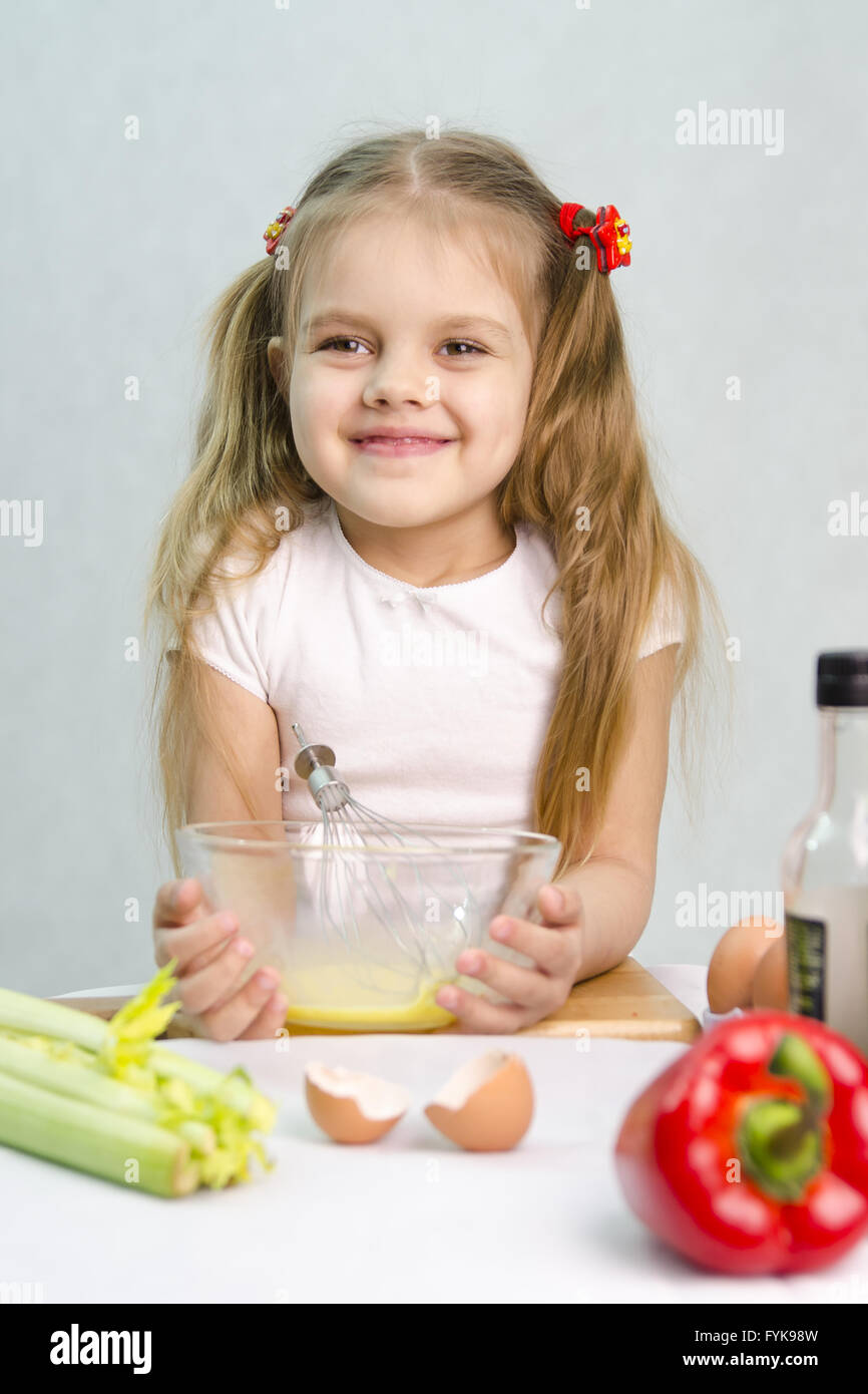 Girl playing a cook churn whisk eggs in glass bowl Stock Photo - Alamy