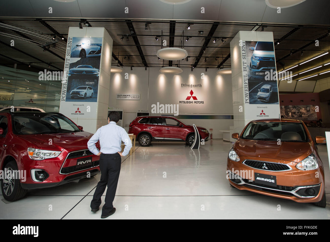 Tokyo, Japan. 27th Apr, 2016. A businessman looks at a Mitsubishi RVR ...
