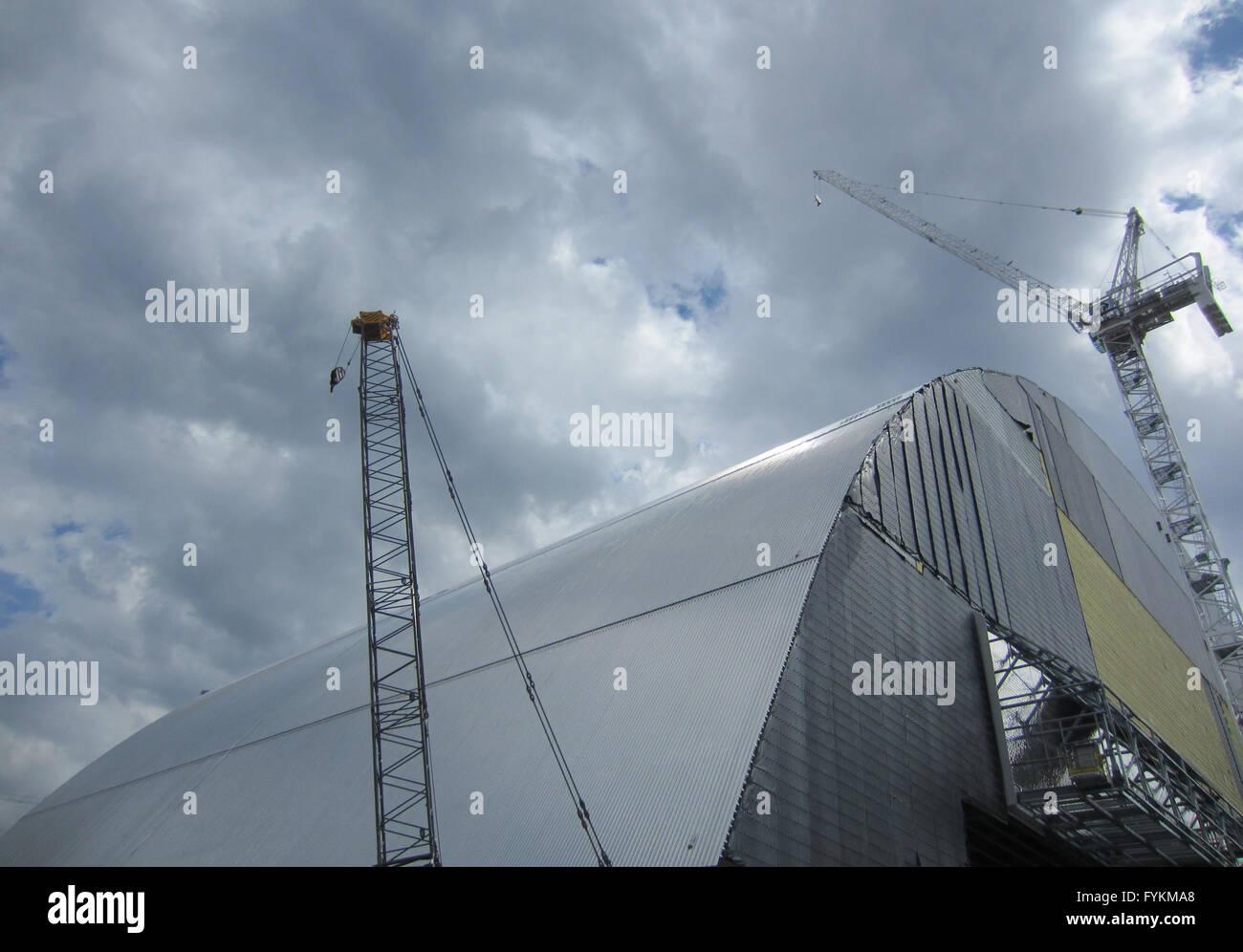 A construction crane towers above the stainless steel safe confinement ...