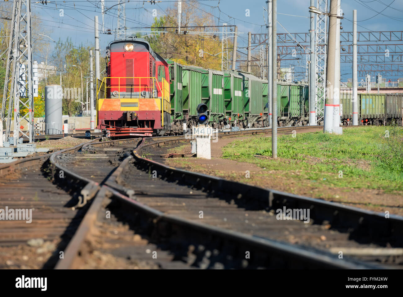 Red locomotive and Green freight cars on the rails Stock Photo - Alamy