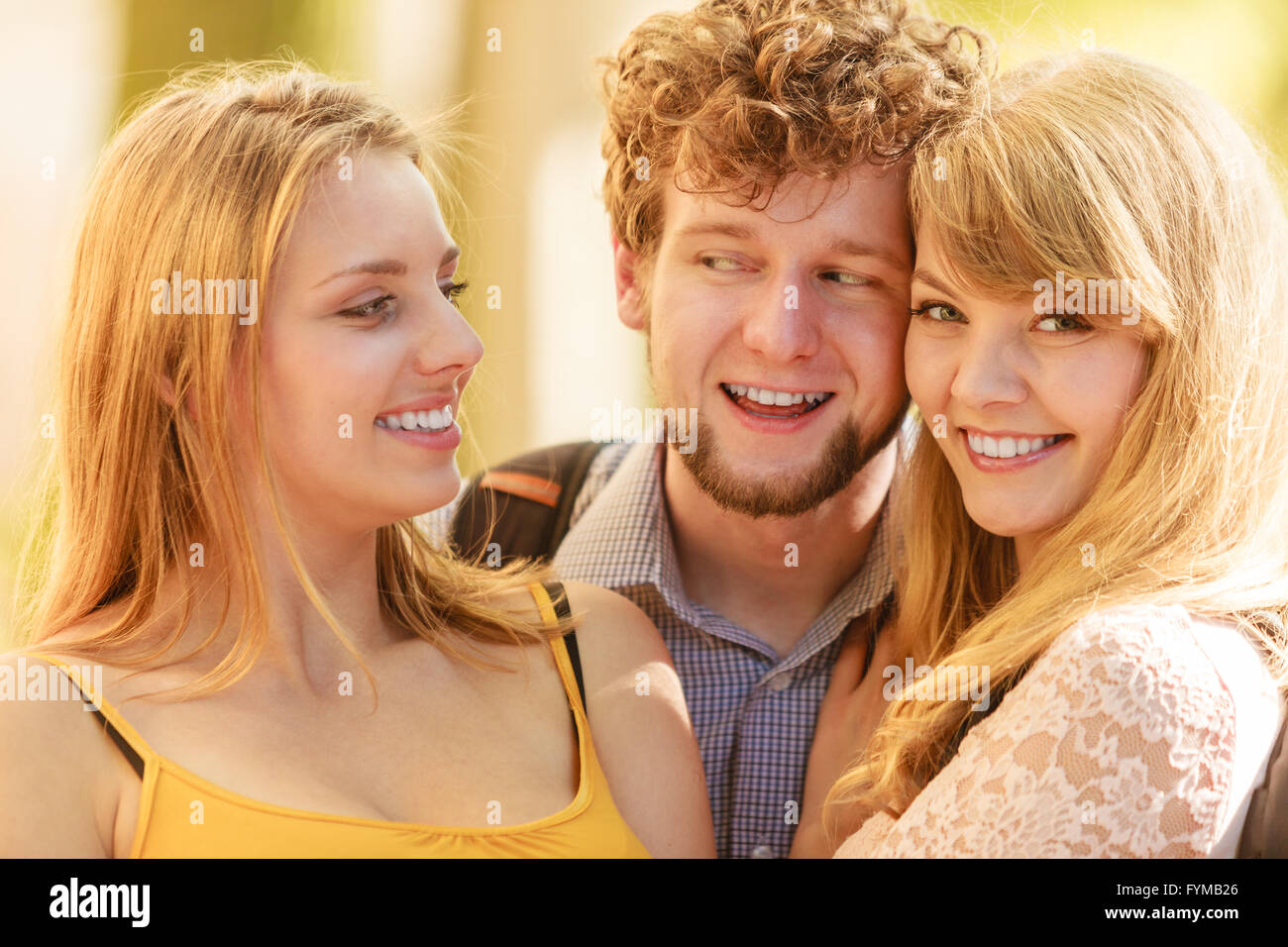 Three happy smiling young people friends outdoor. Attractive women and ...