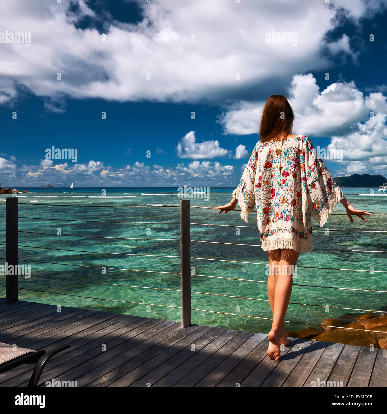 Woman on a beach jetty at Seychelles, La Digue Stock Photo - Alamy