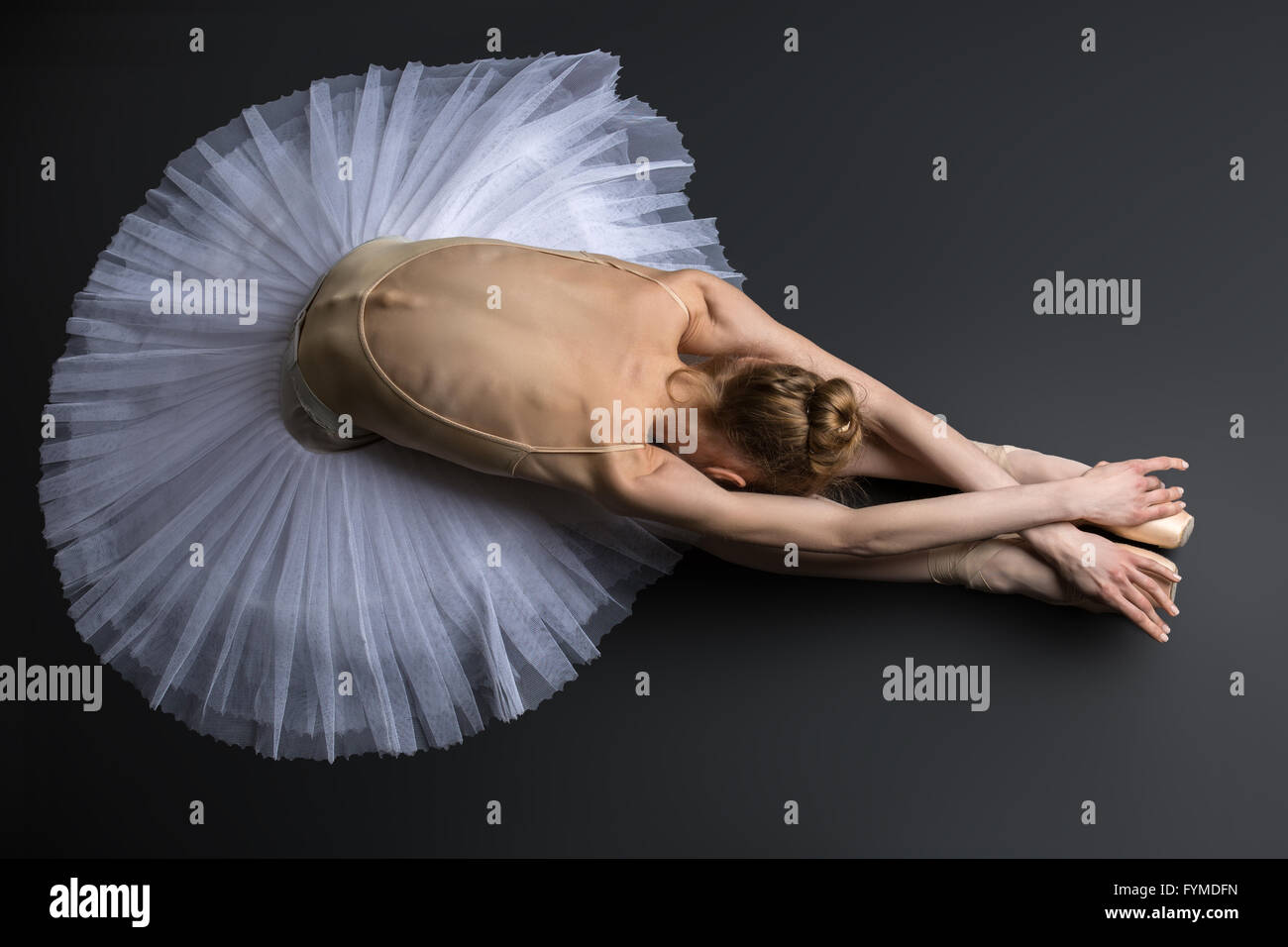 Graceful ballerina sitting on the floor Stock Photo - Alamy