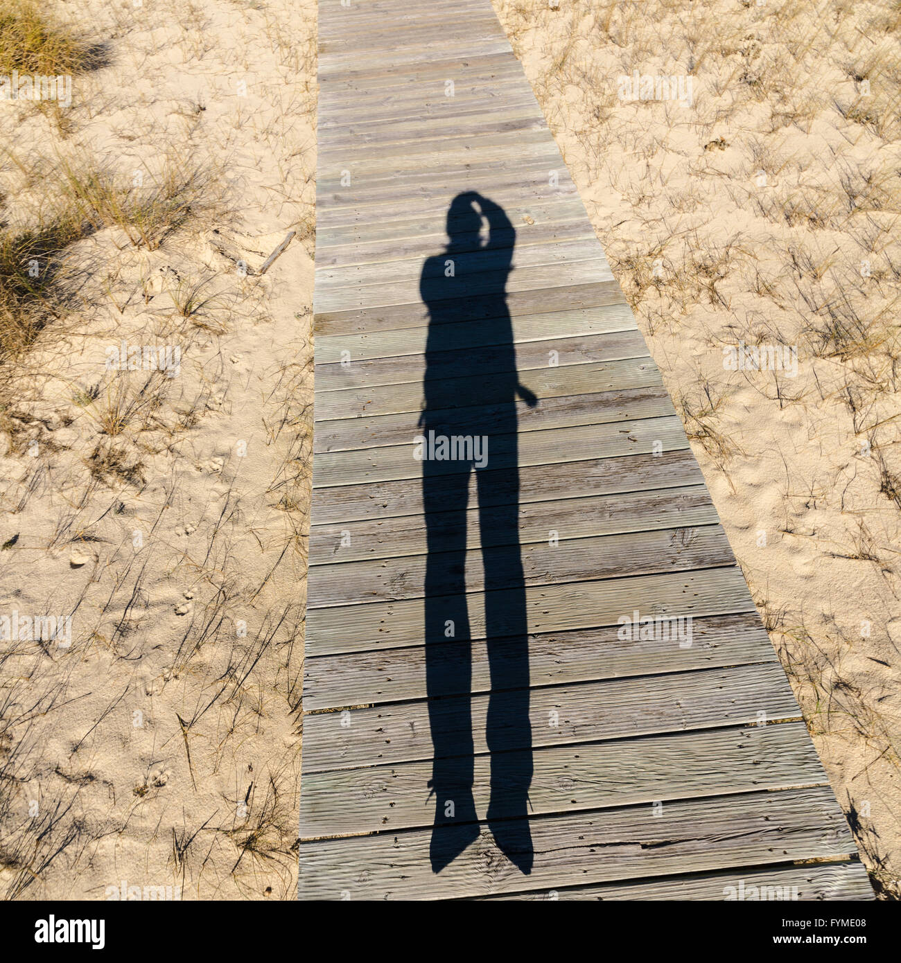 Elongated Shadow Jumping Man on a Wooden Walkway Stock Photo - Alamy