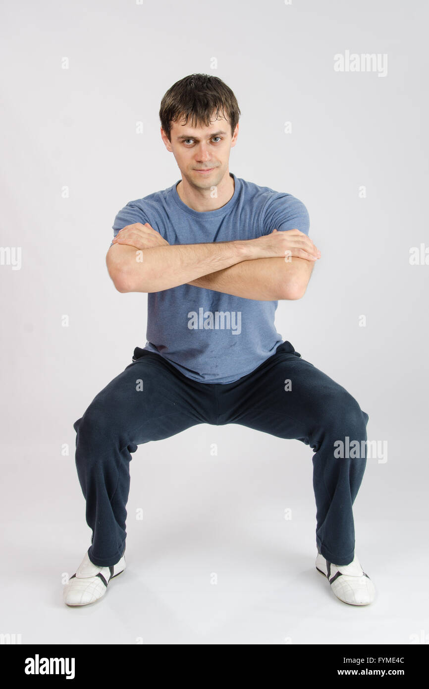 young man performs squats Stock Photo - Alamy