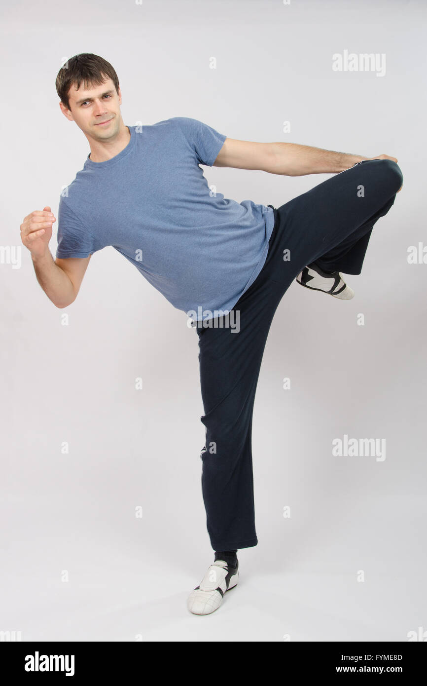 Young man flexing muscles of the legs Stock Photo - Alamy