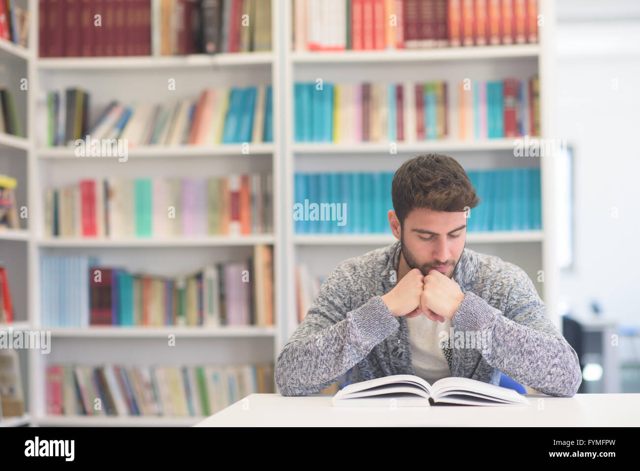 Portrait of happy student while reading book in school library. Study ...