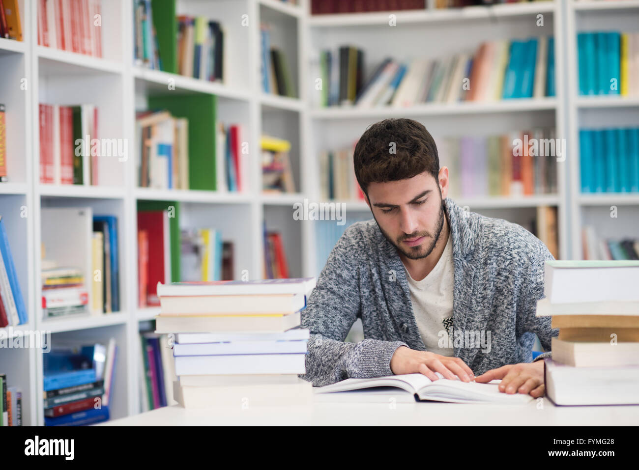 Portrait of happy student while reading book in school library. Study ...
