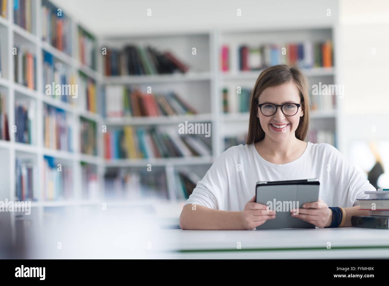 female student study in school library, using tablet and searching for ...