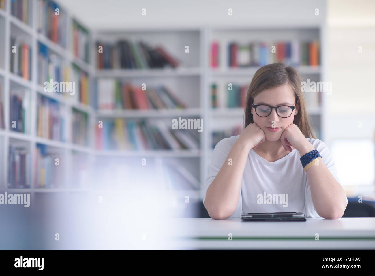 female student study in school library, using tablet and searching for ...