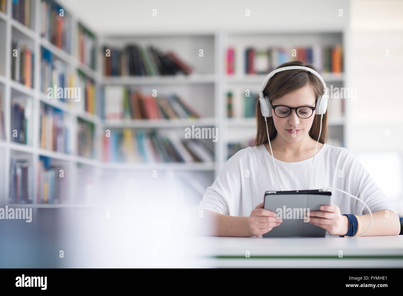 female student study in school library, using tablet and searching for ...